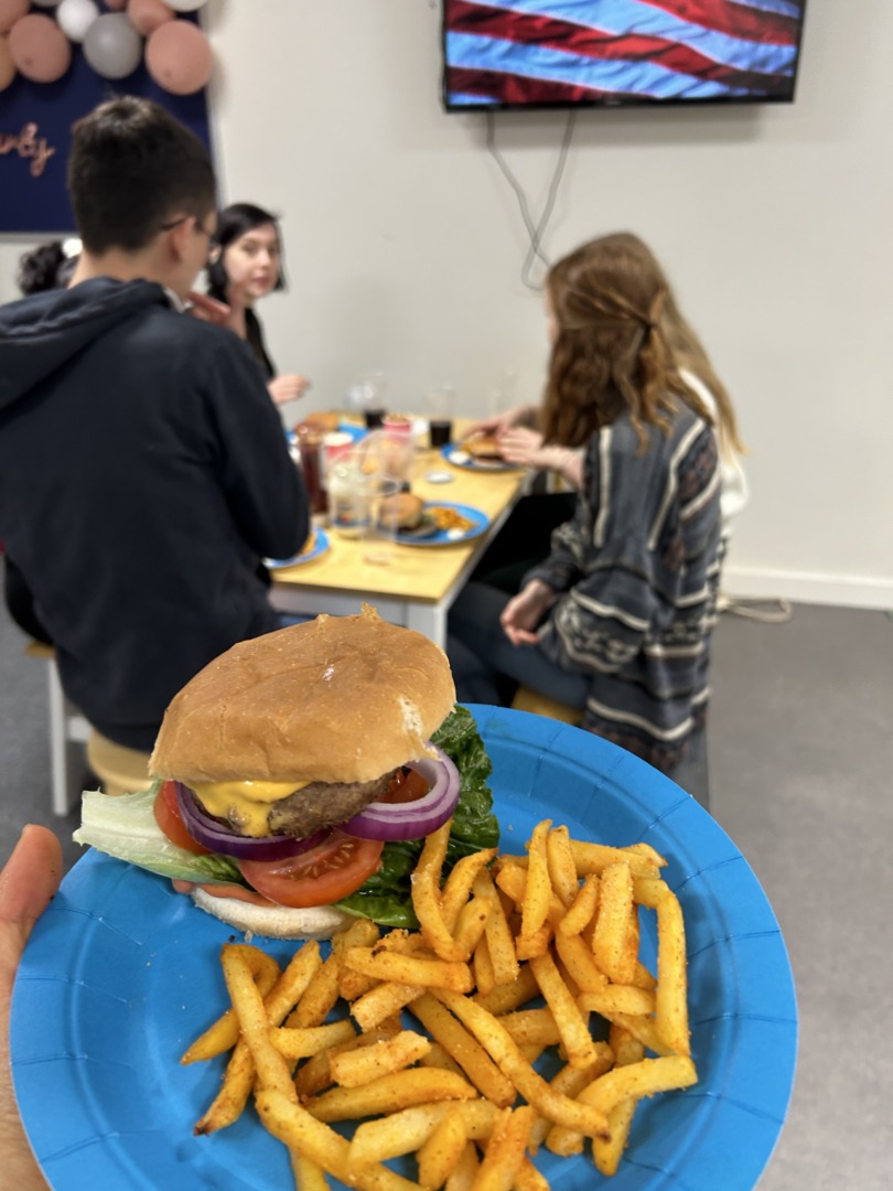 Pachta holds a plate with a cheeseburger and seasoned fries during her ...